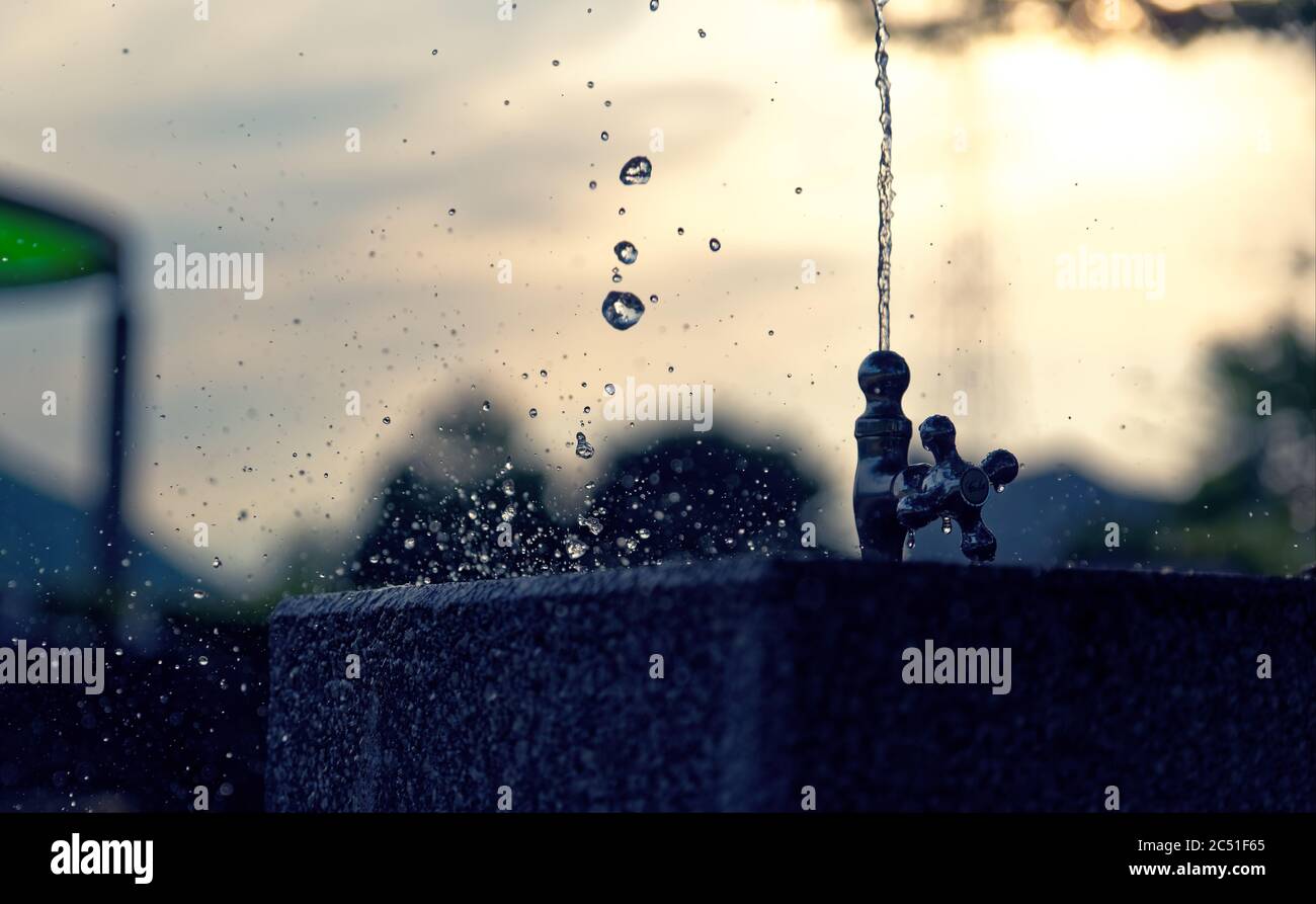 Water shooting up from a fountain and splashing on basin below in the ...