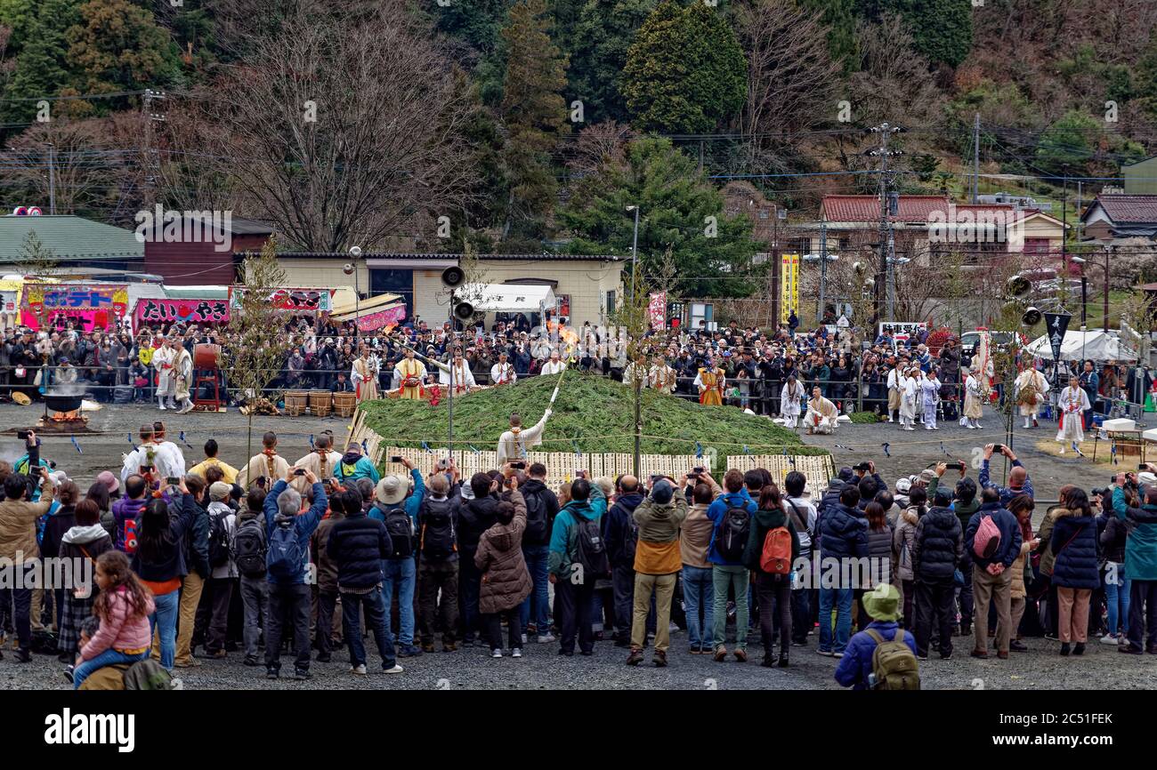 A large crowd watches as monks holding torches prepare to light the ...