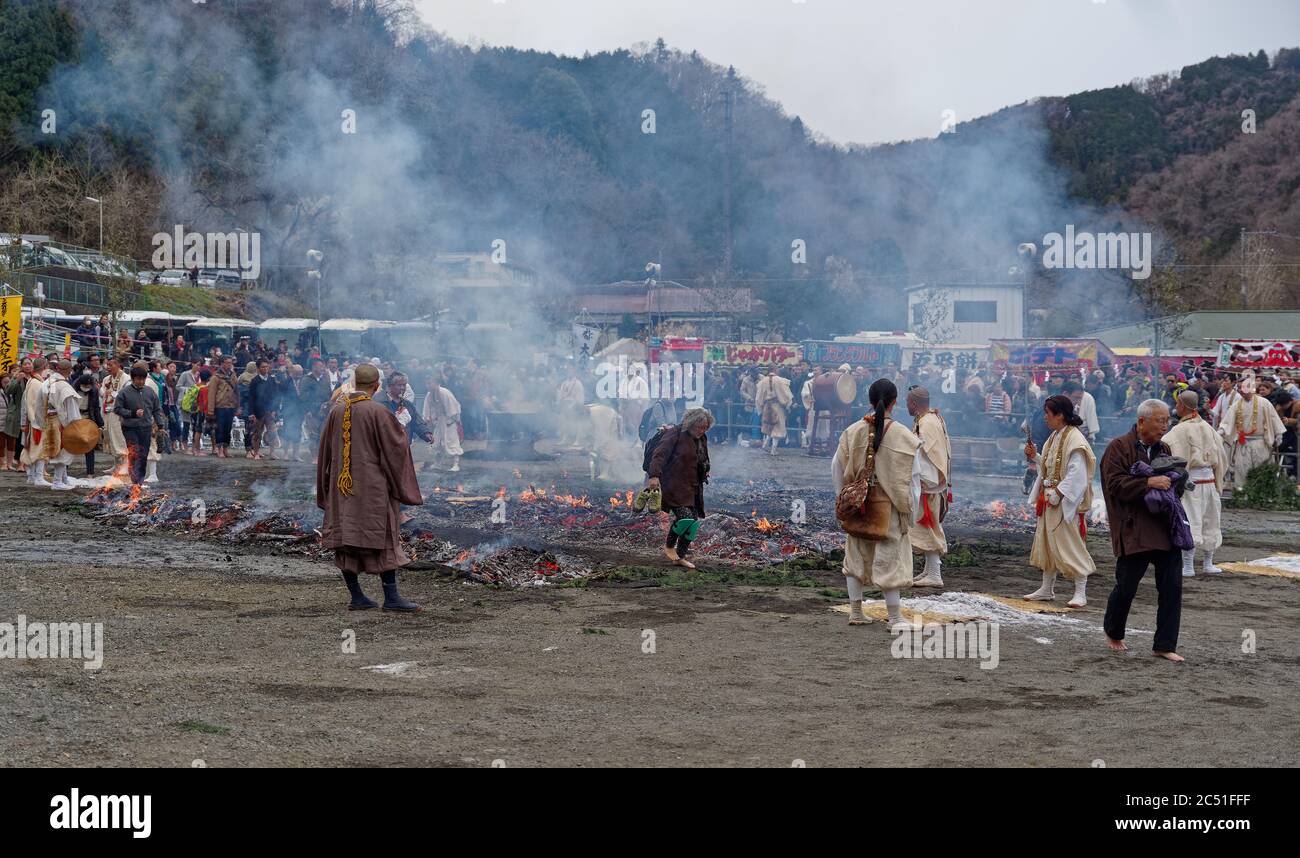 An old woman crosses the fire-walking space as monks and a large crowd ...
