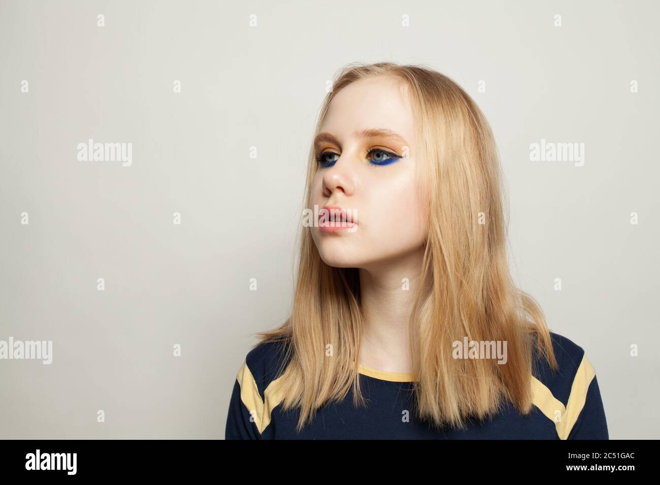 Blonde girl with blue eye shadow makeup on white background Stock Photo ...