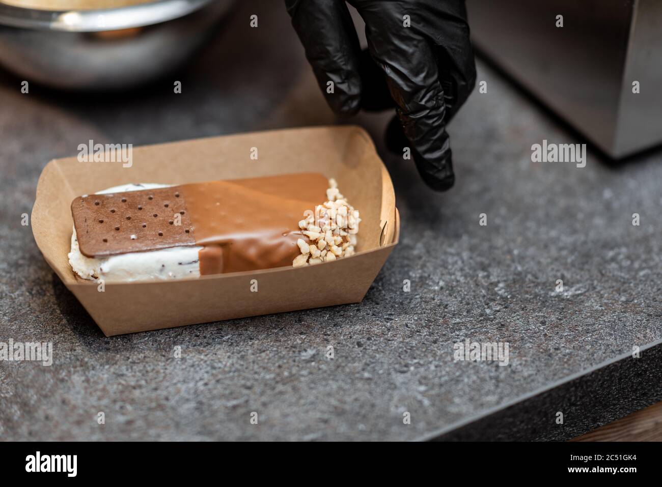 Chef holding cardboard with a chocolate ice cream on a stick with ...