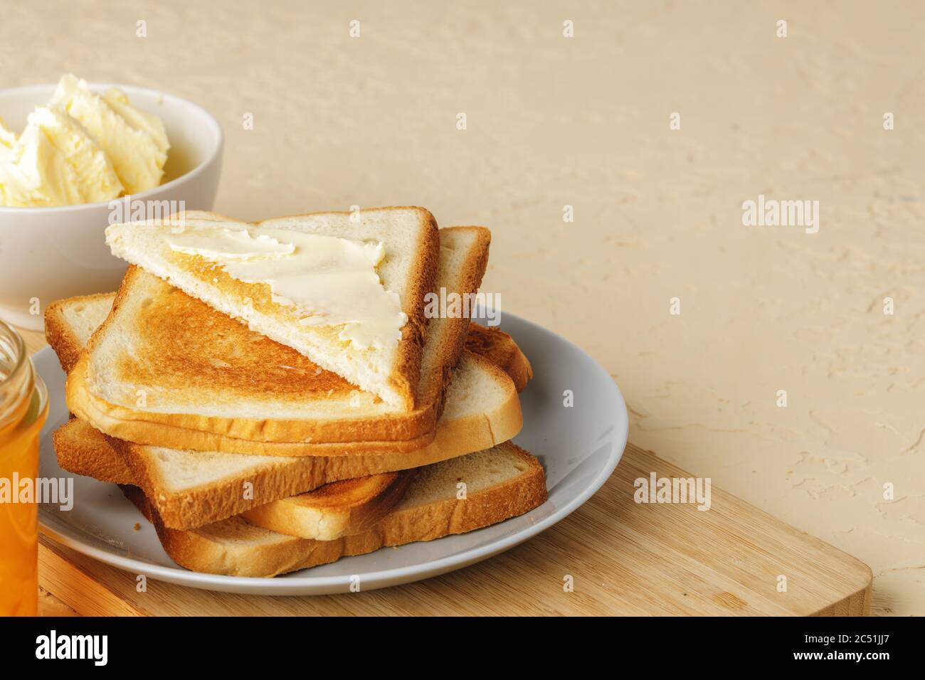 Simple breakfast. Toasted bread covered with butter Stock Photo - Alamy