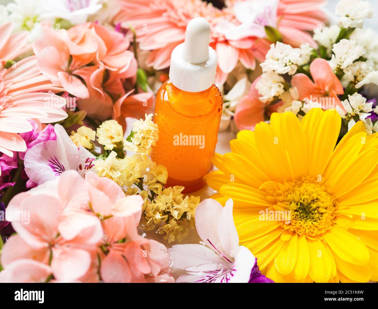 Skin care serum in orange bottle with flowers Stock Photo - Alamy