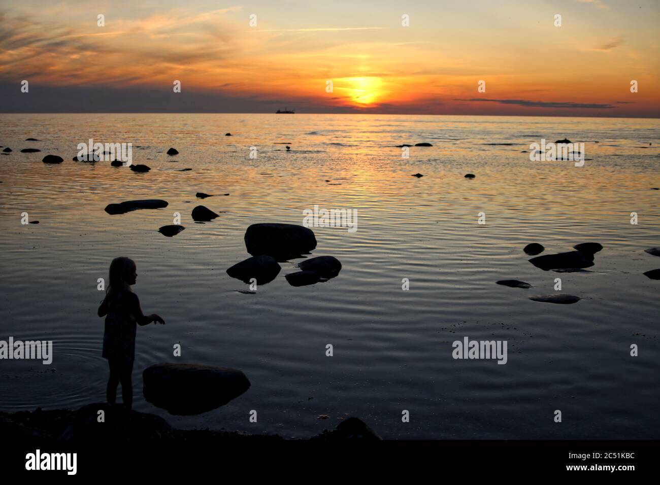 A girl watching the sunset in Gotland sweden during summer Stock Photo ...