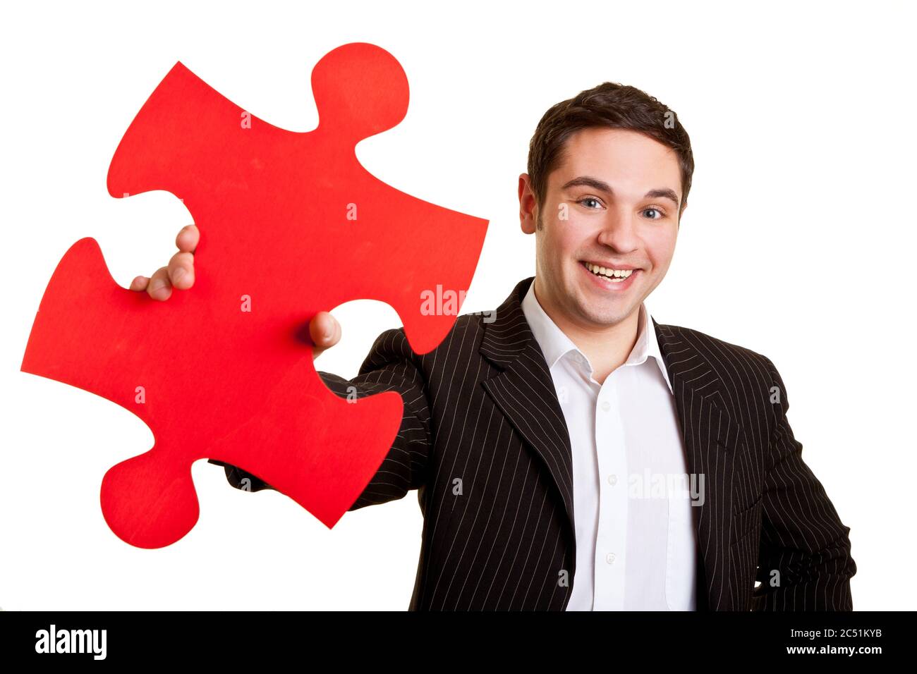 Laughing businessman holds a red puzzle piece Stock Photo - Alamy