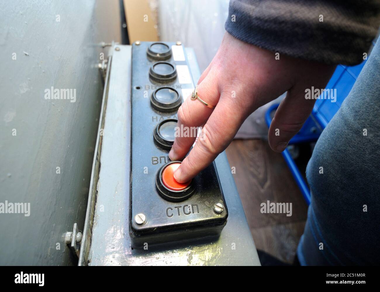 Woman finger pushing button Stop on control panel of a belt conveyor ...