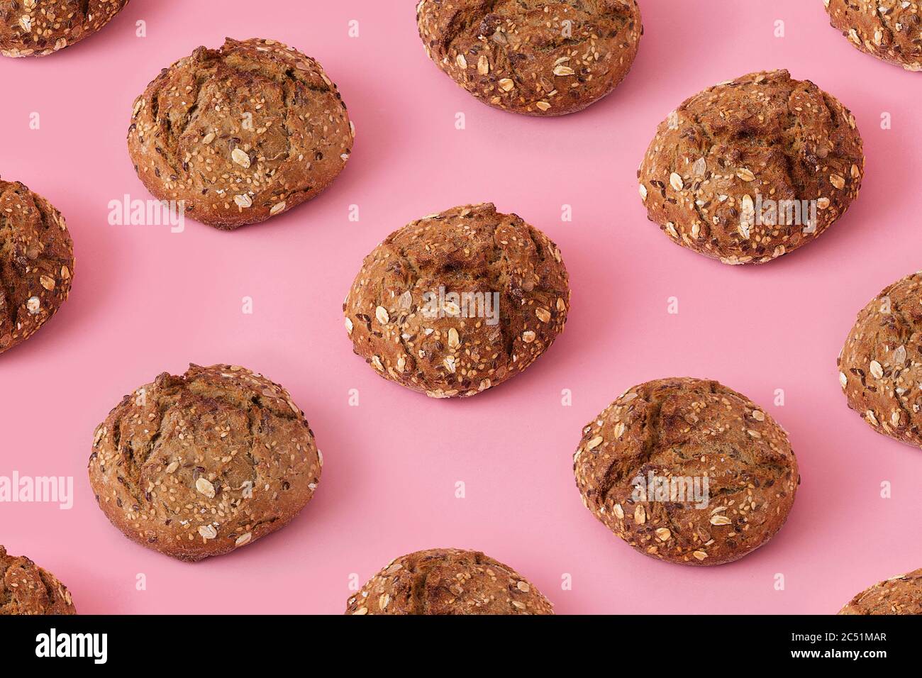 Brown bread buns with seeds on pink background, creative colorful ...