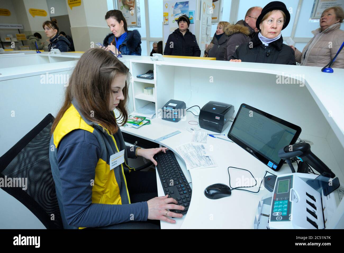 At the post office, reception: postal worker sitting at the desk set ...