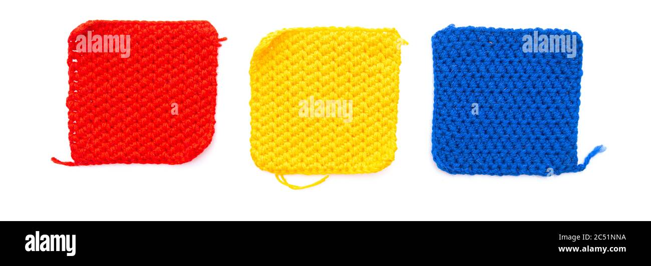 Three knitted patch squares: red, yellow, blue isolated on white ...