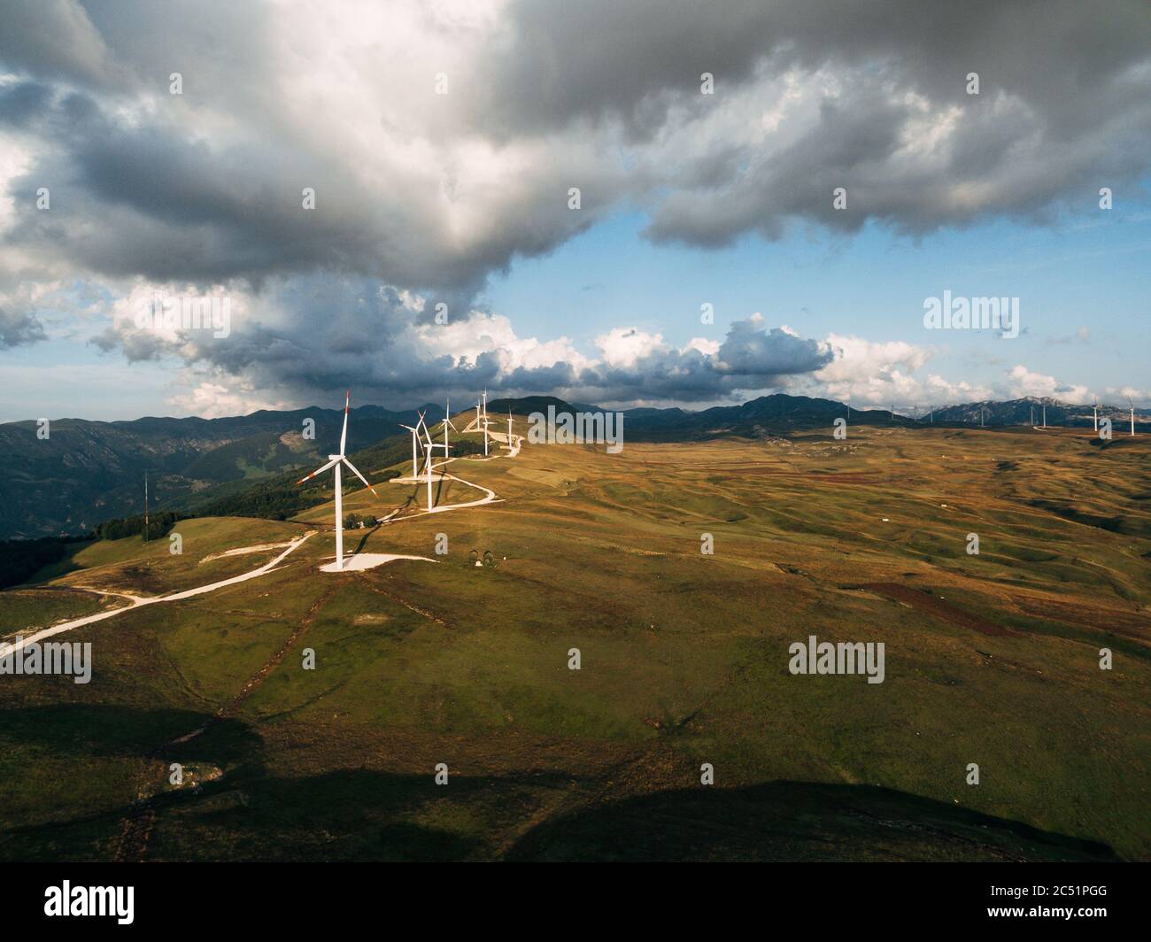 Aerial photo from a drone - a series of huge high wind turbines along a ...