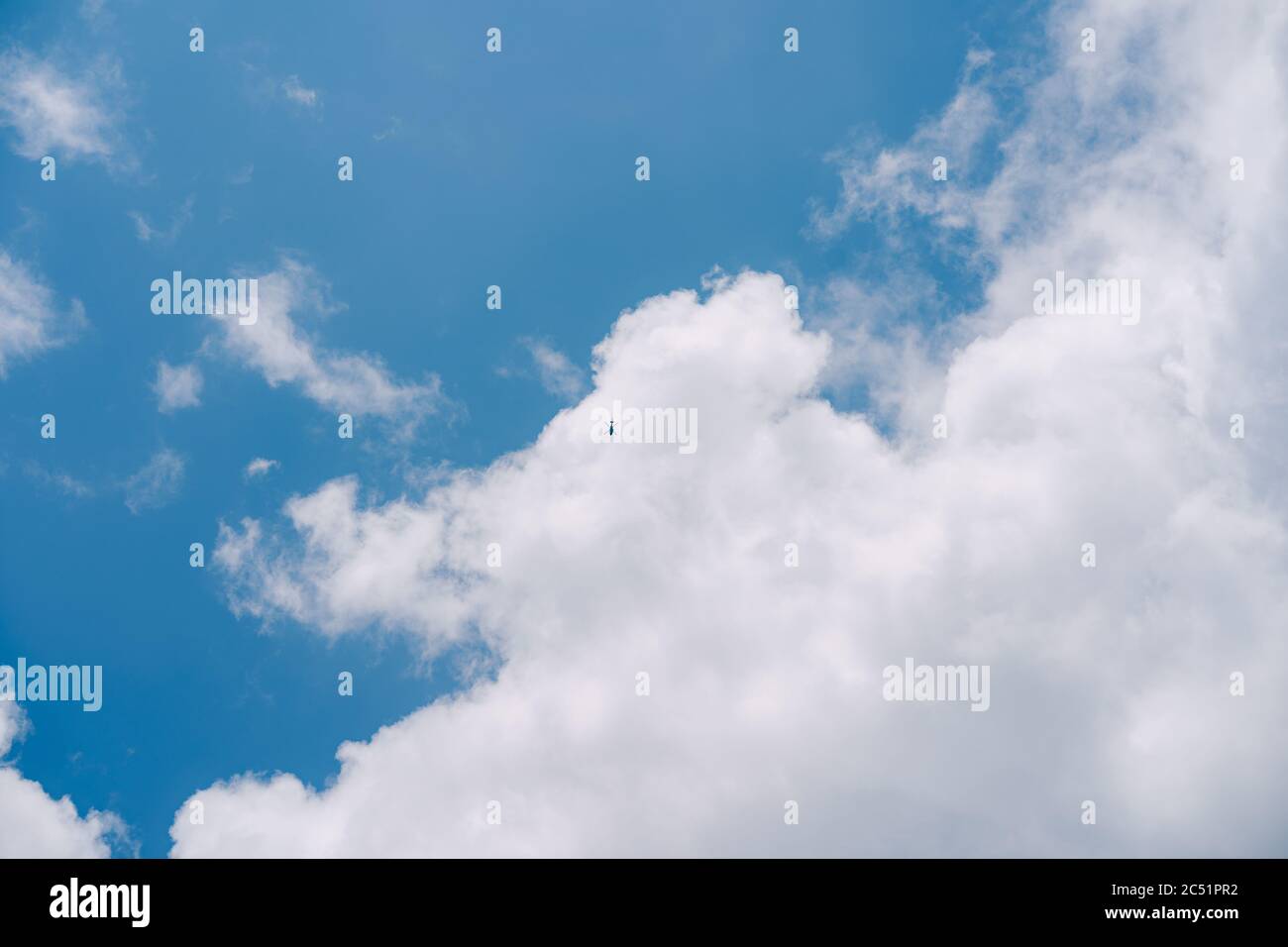 Passenger helicopter flies in the sky among the clouds Stock Photo - Alamy