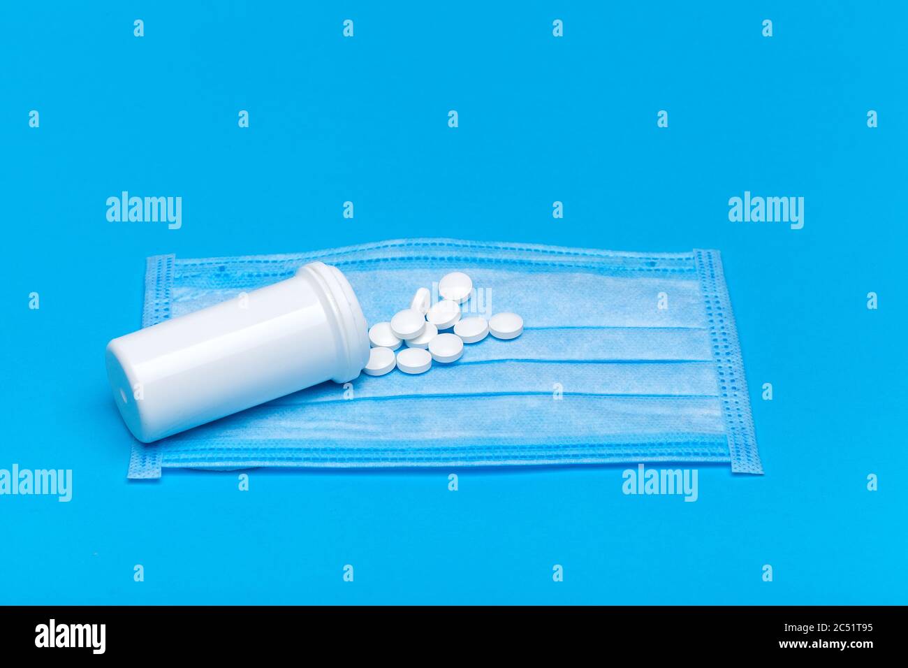 medical mask with a bottle of a medicinal product with a scattered pile ...