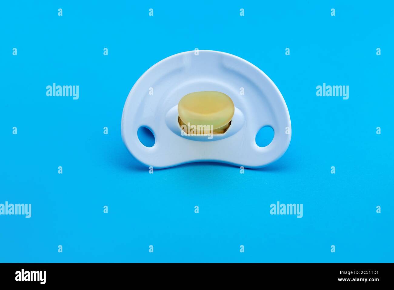 a blue pacifier made of soft silicone isolated on blue background front ...