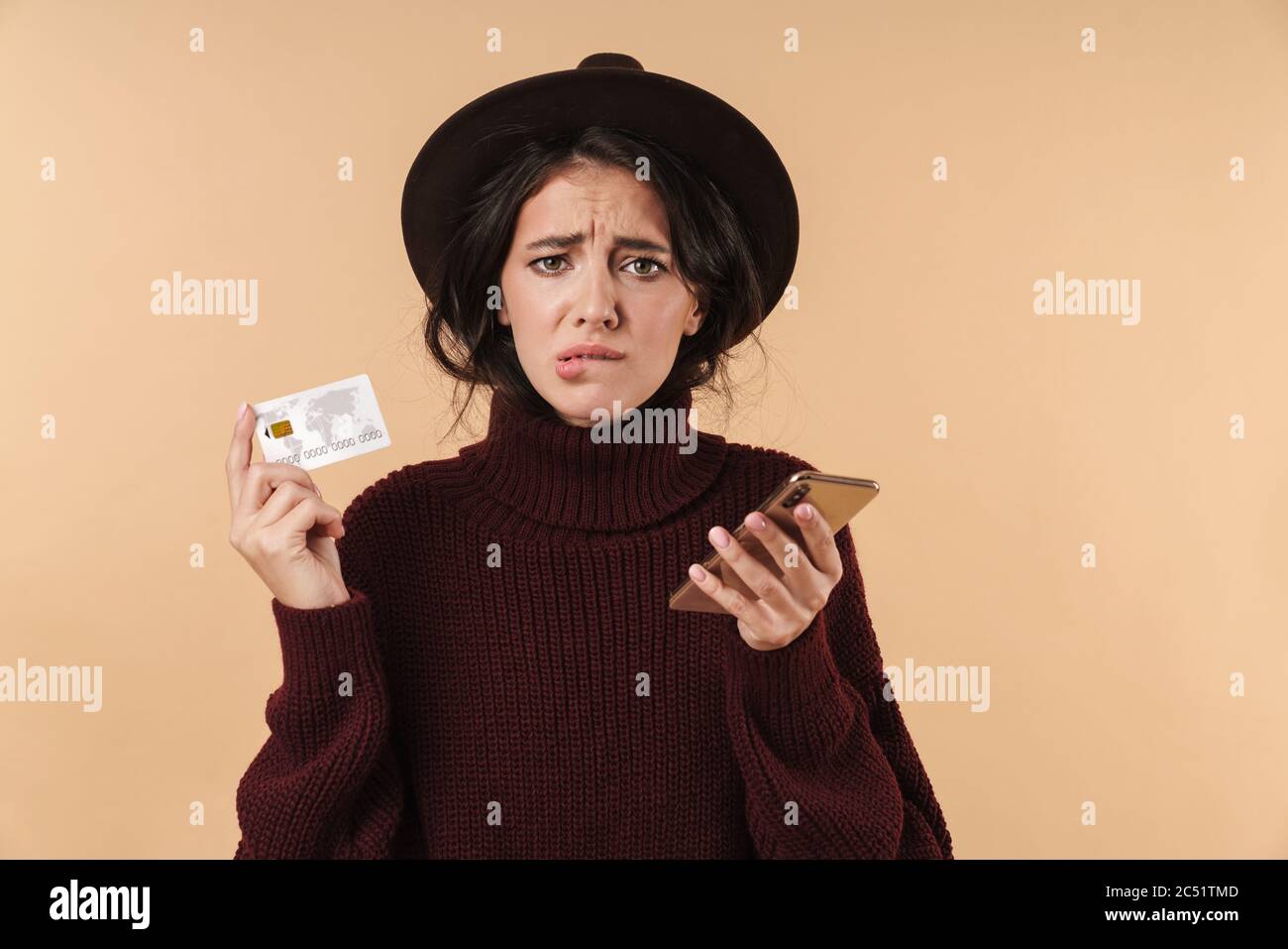 Image of nervous young brunette woman bite lip isolated over beige wall ...