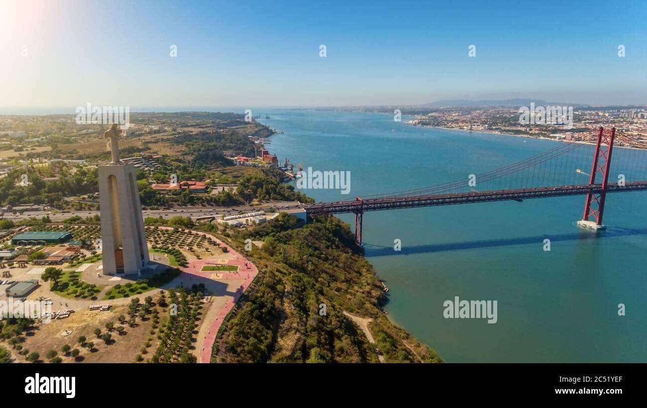 Aerial bridge on April 25th, across the Tejo River, statue of Jesus ...