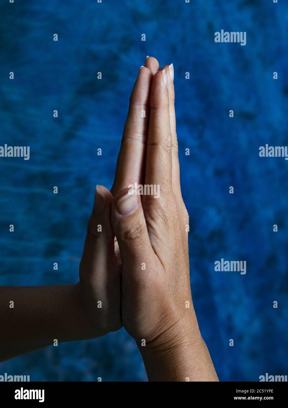 Closeup vertical shot of two hands pressed on each other on a marble ...