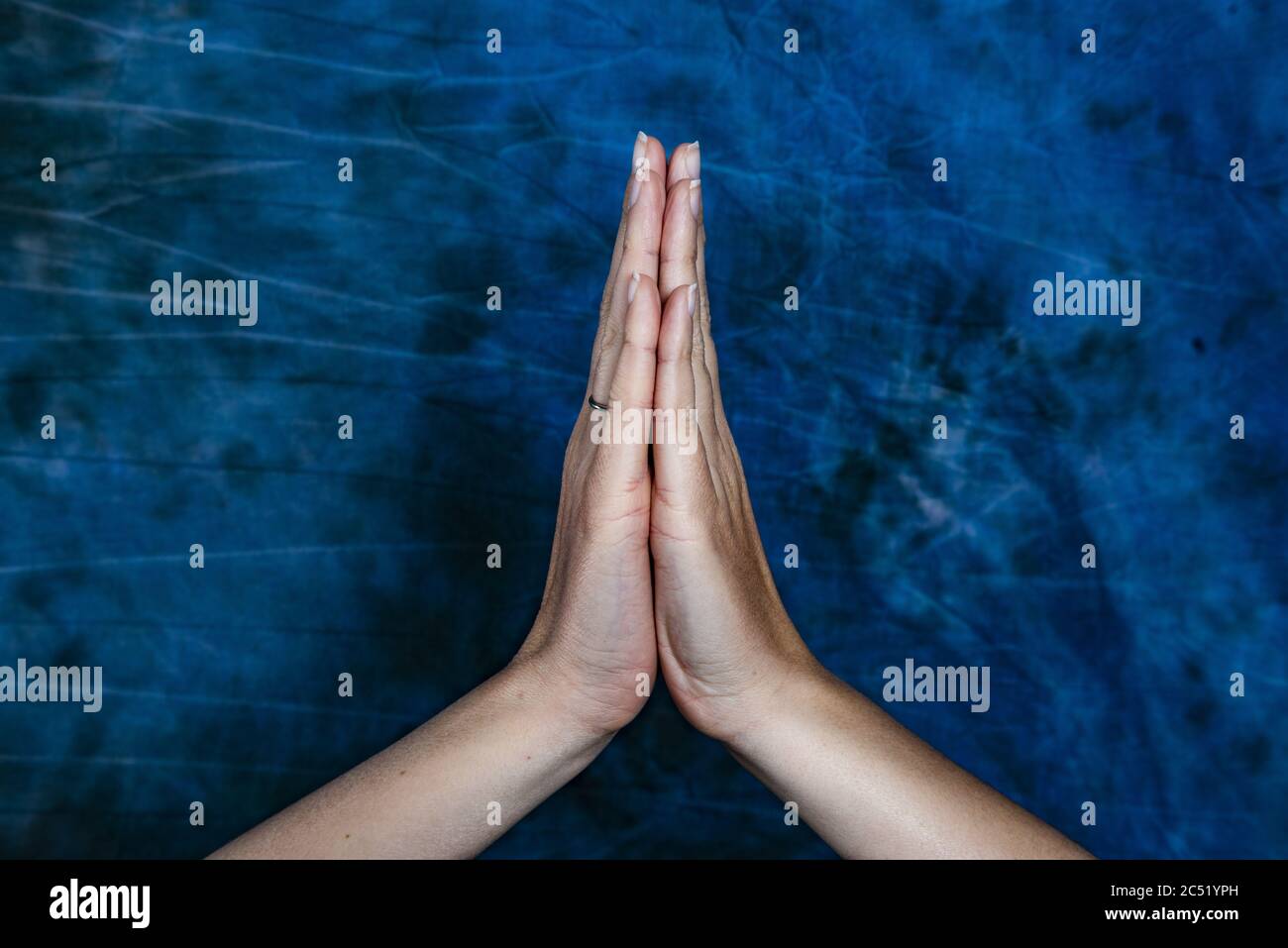 Horizontal shot of two hands pressed on each other on a marble blue ...