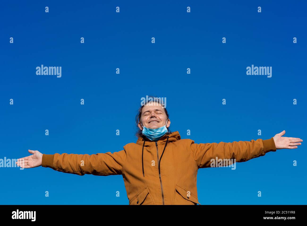 a joyful man with his hands apart, took off the mask from his face and ...