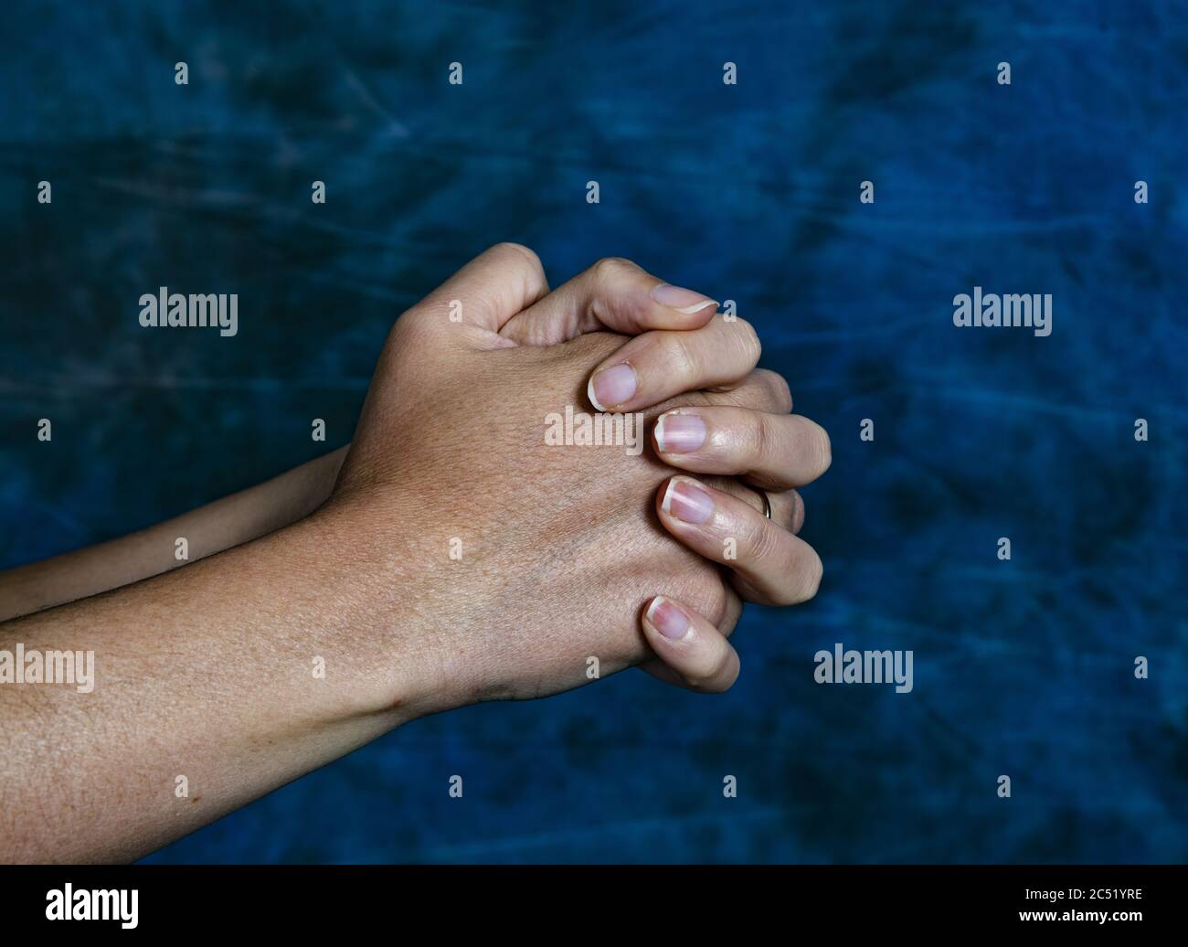 Horizontal closeup shot of two hands locked together from a side on a ...