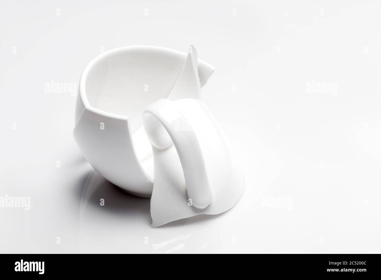 fragments of parts a broken cup with a handle after falling on a white ...