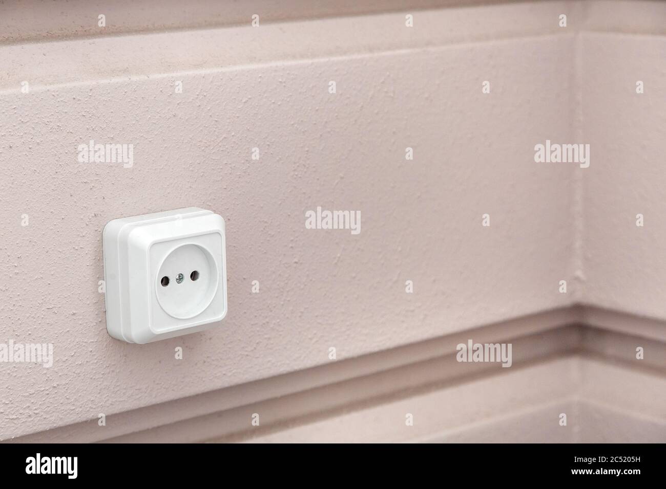 external white plastic outlet mounted on a wall with decorative plaster ...