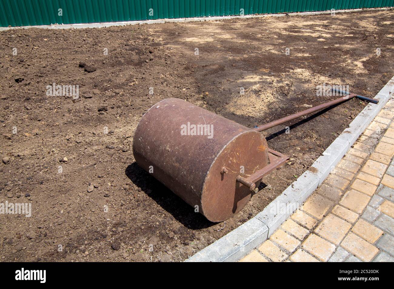 garden roller for compaction of the soil an iron shaft lies on the ...
