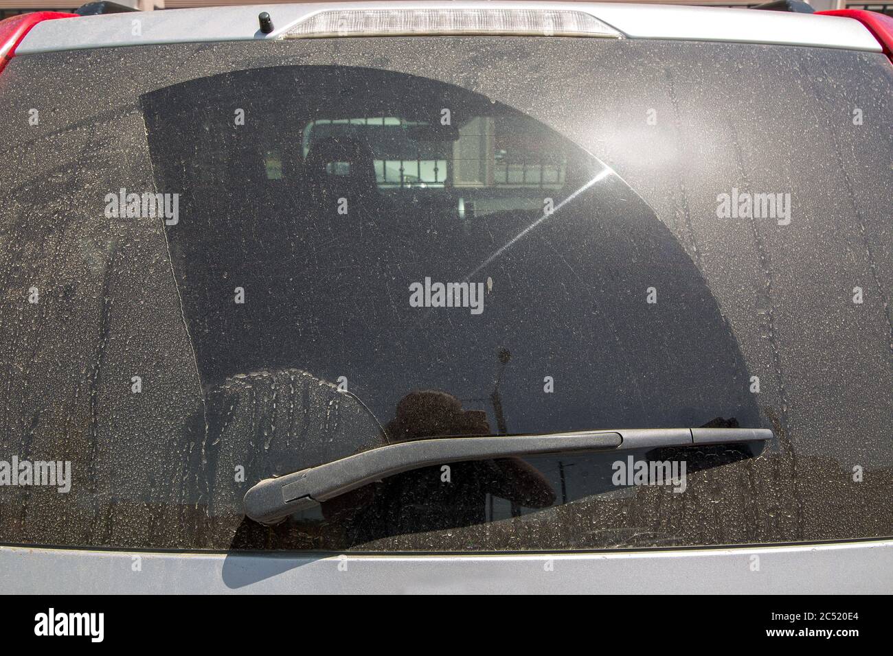 back window of a dirty car covered in dust in a dry mud rear view of a ...