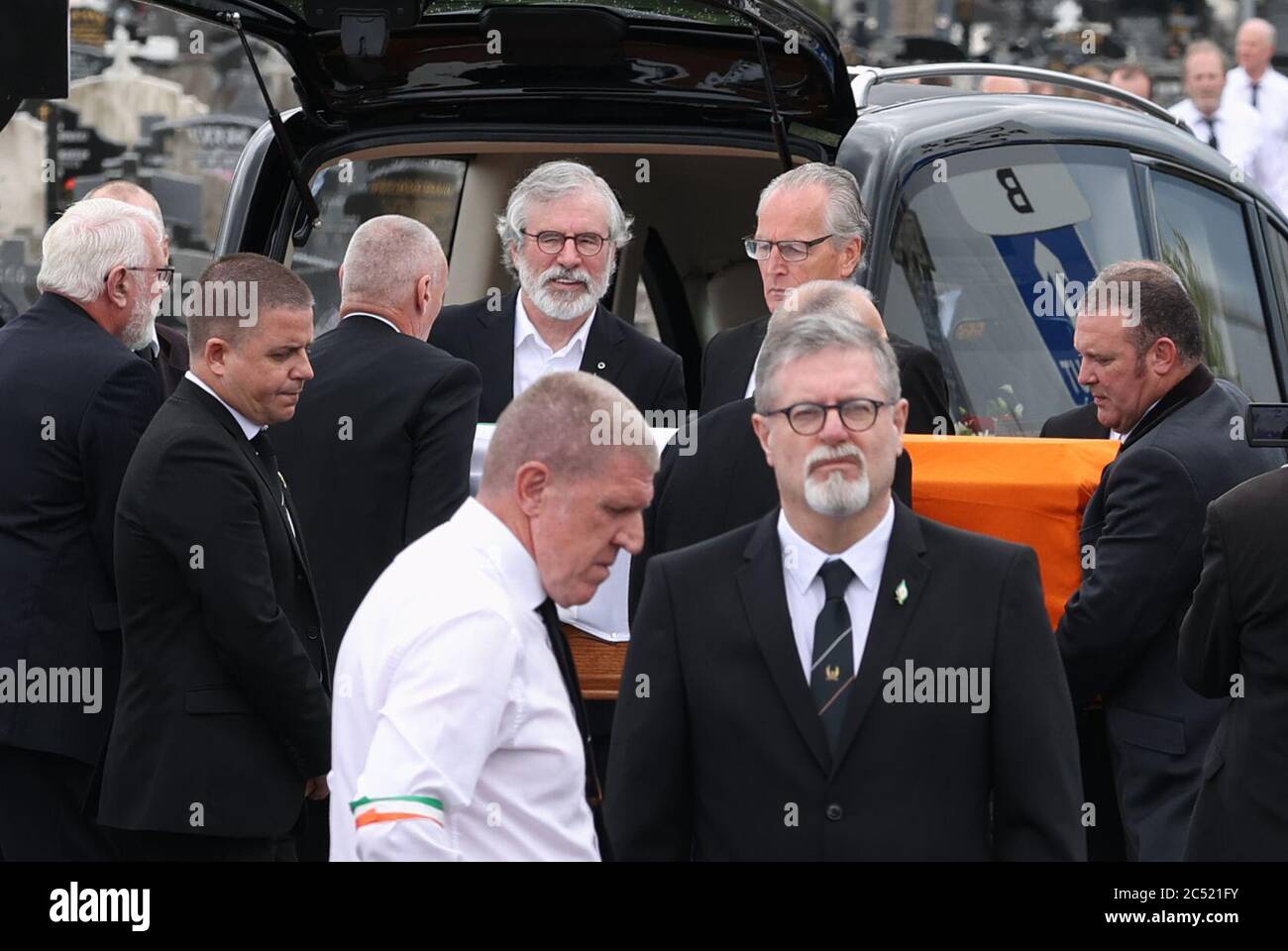 Gerry Adams (back centre) and Gerry Kelly (back right) help to carry ...