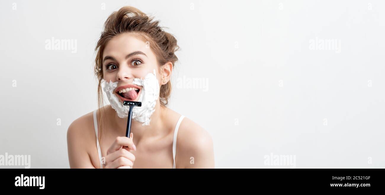 Beautiful young caucasian woman shaving her face by razor on white ...