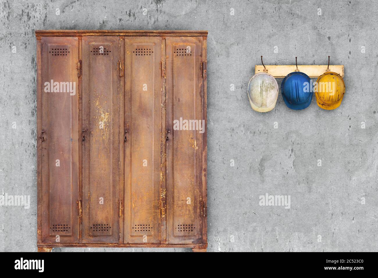 Vintage rusted locker and construction helmets hanging on a hat-rack in ...