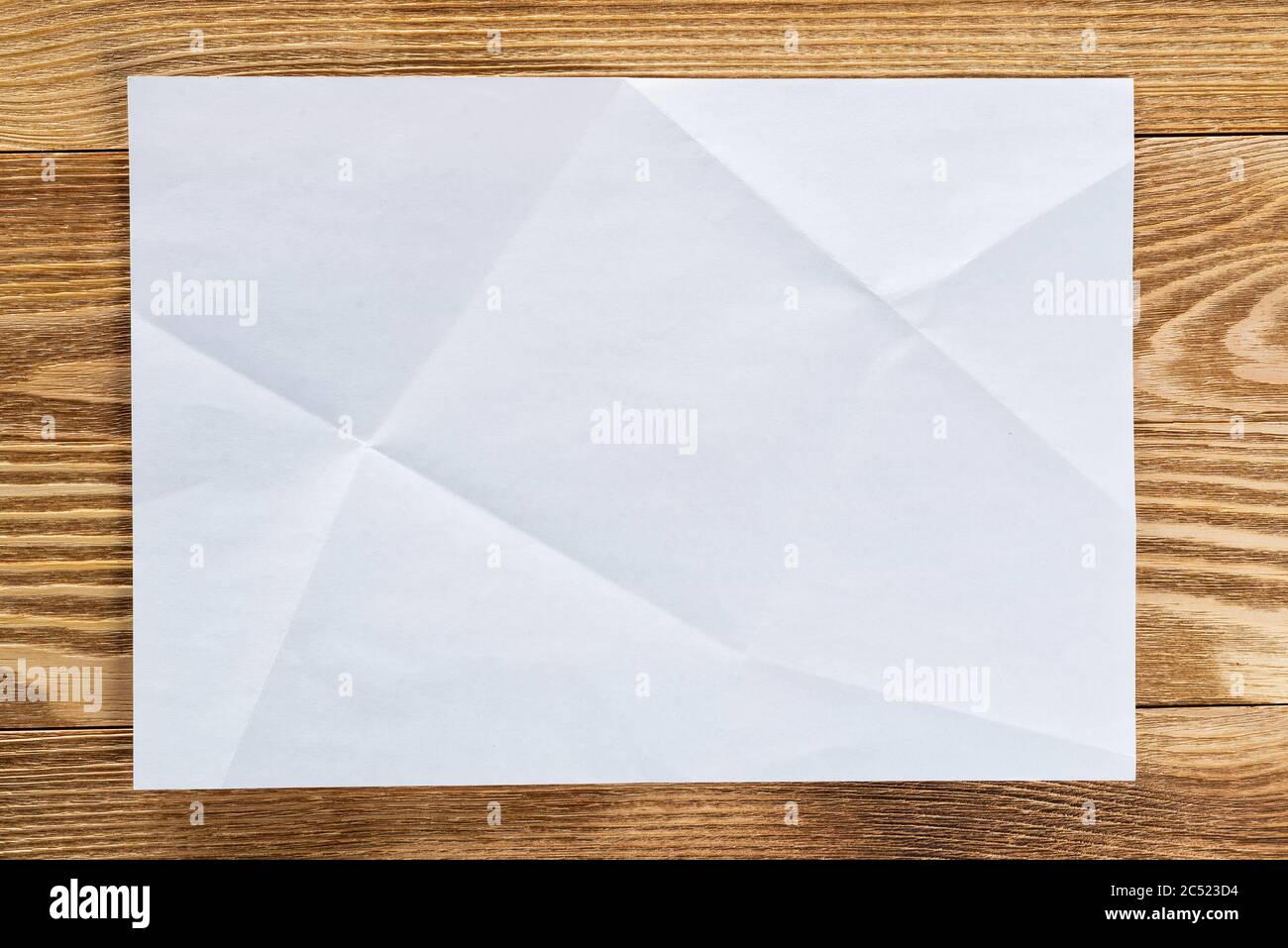 Sheet of paper lying on wooden table Stock Photo - Alamy