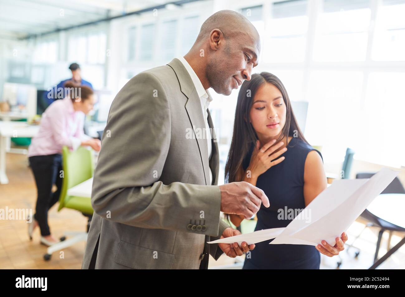 Multicultural business people in the office talk together about business documents Stock Photo ...