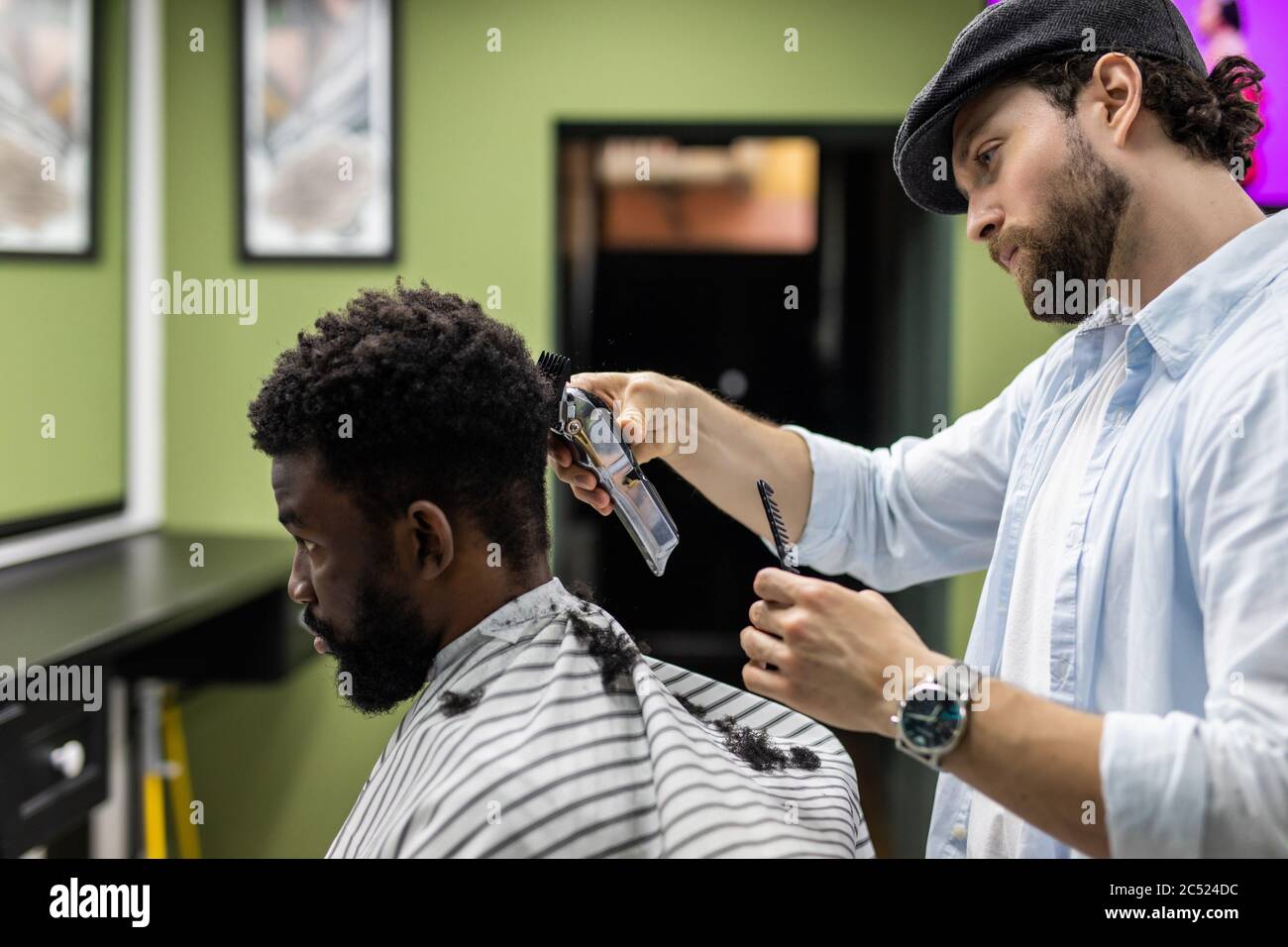 Closeup of process of trimming of hair in barber shop. Qualified barber ...