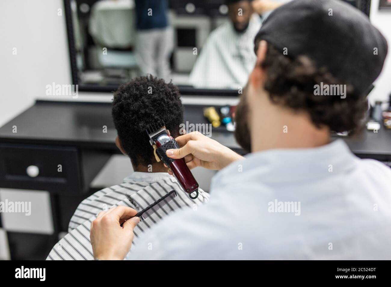 Side view of man with stylish modern haircut looking forward in barber ...