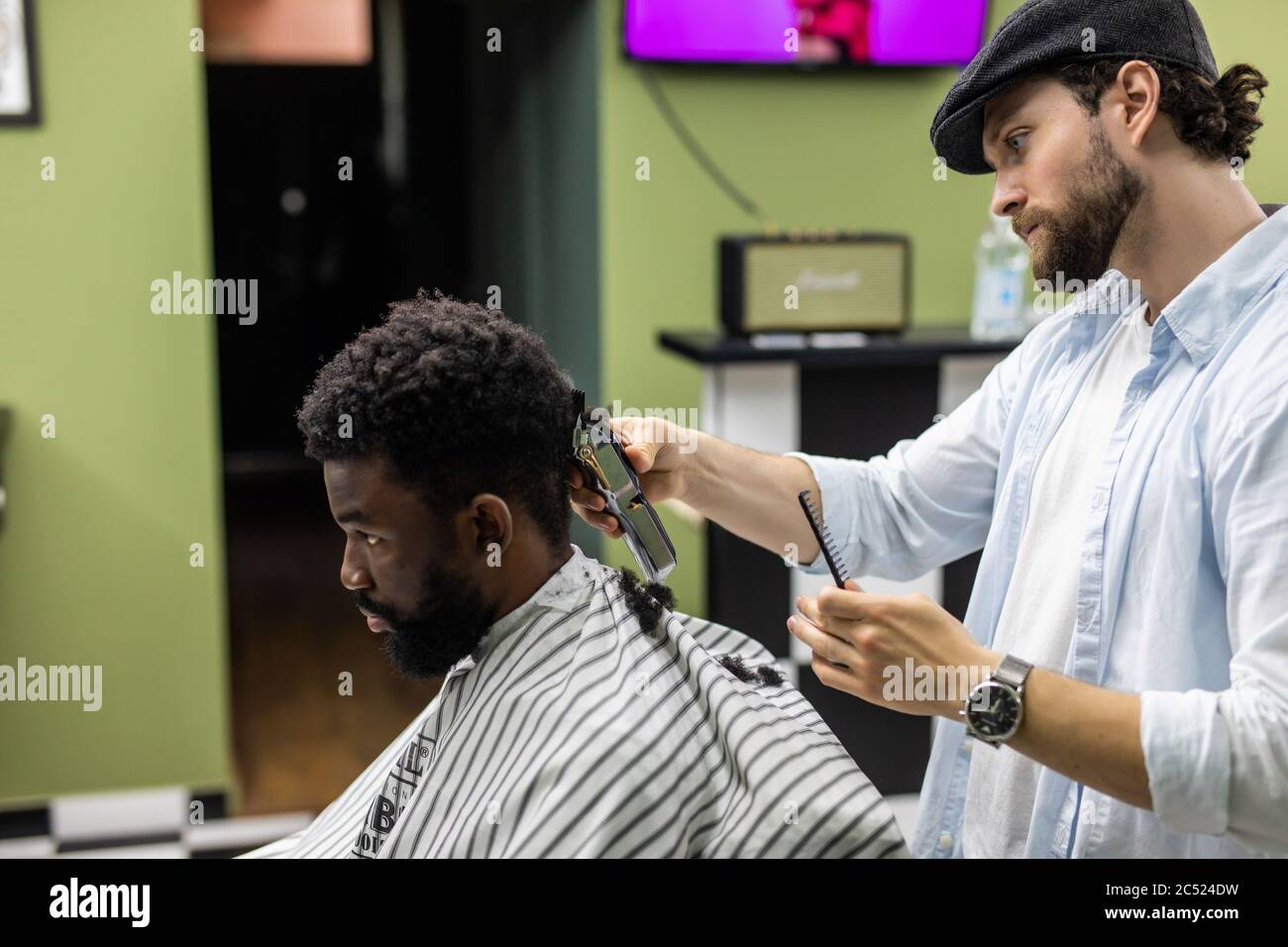 Side view of man with stylish modern haircut looking forward in barber ...