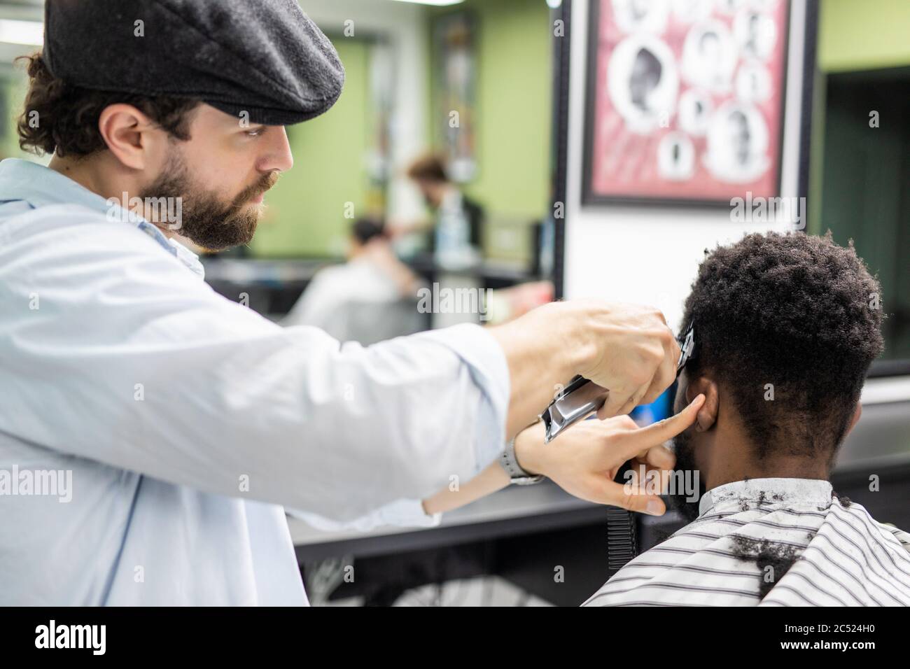 Closeup of process of trimming of hair in barber shop. Qualified barber ...
