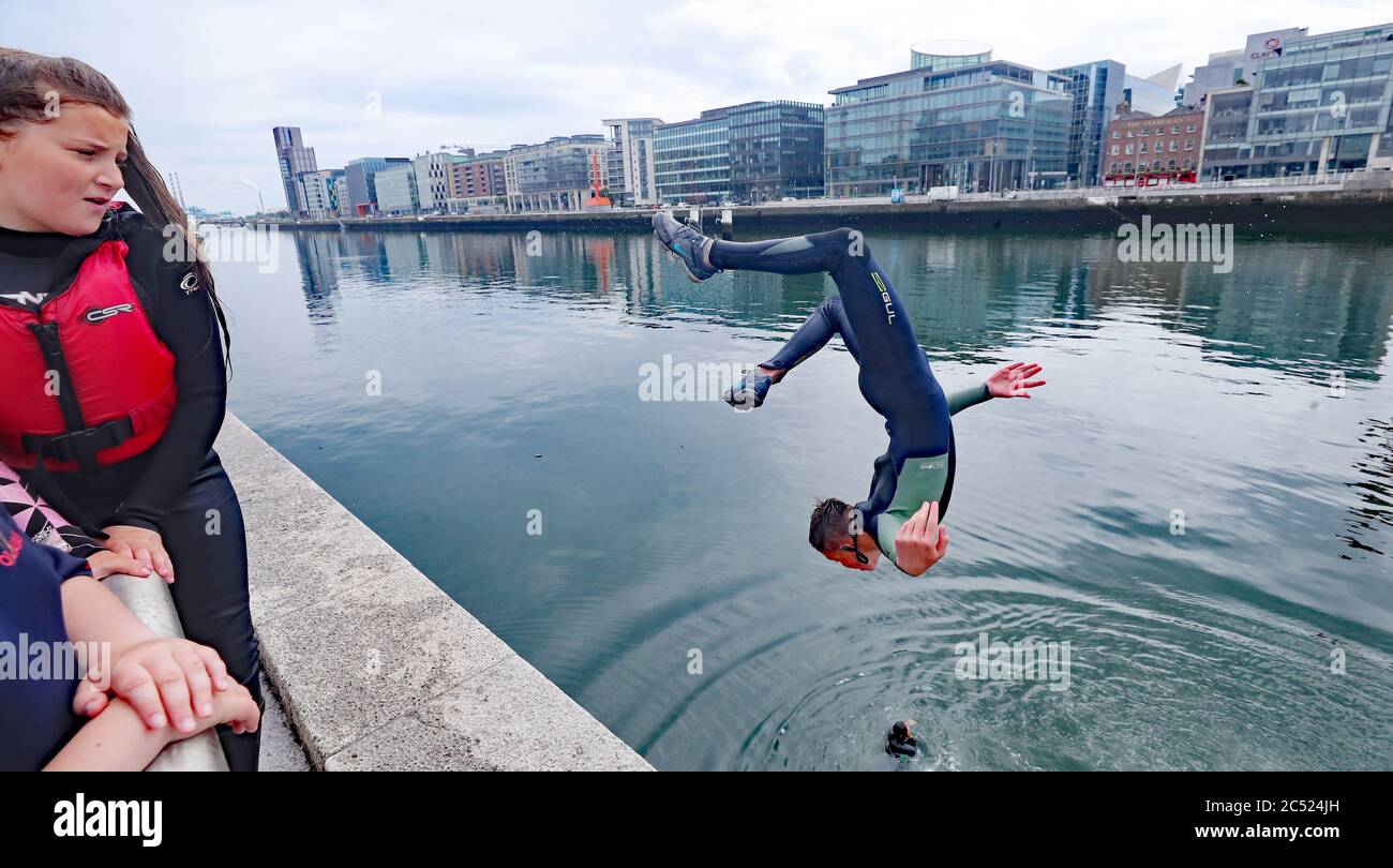 Evan Burke jumps into the river Liffey in Dublin, as rain, wind and ...