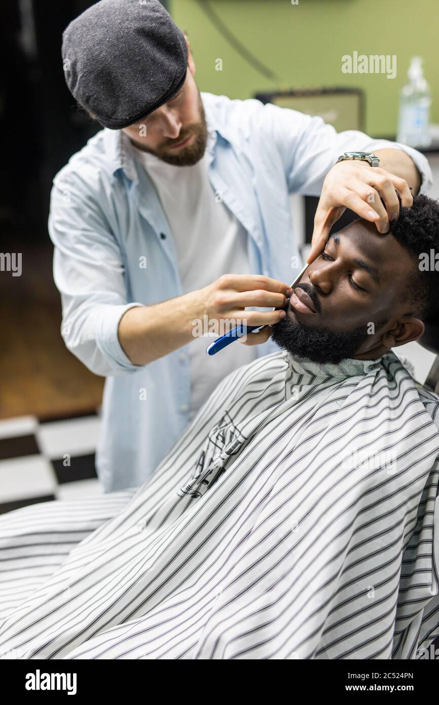 Side view of serious man with stylish modern haircut looking forward in ...