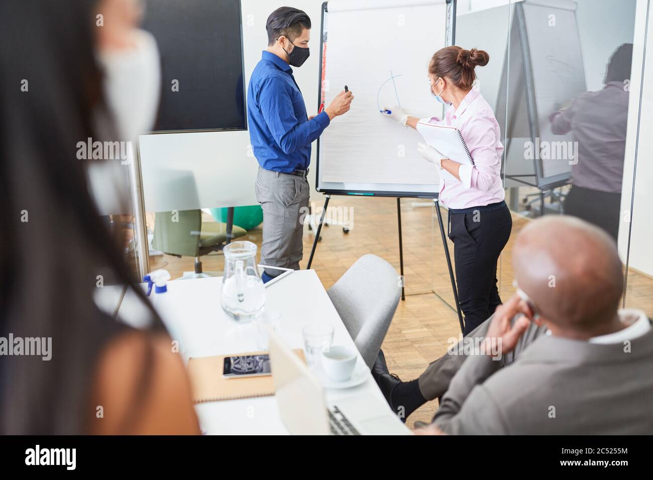 Business people with face mask giving a presentation on flipchart for ...