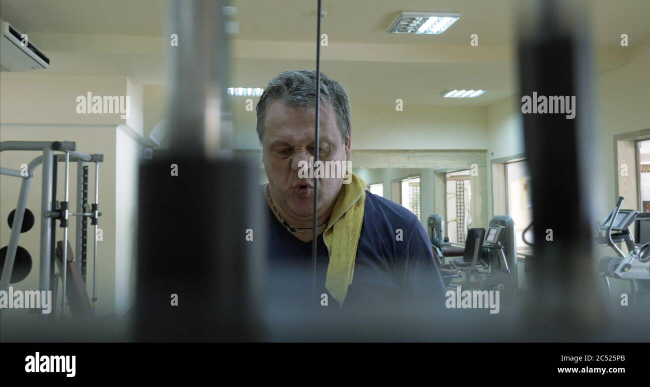 Fitness in modern equipped gym. Mature man doing exercise on lat pull ...