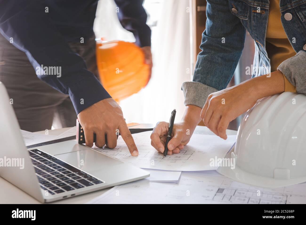 Architects are discussing and planning together at the desk with ...