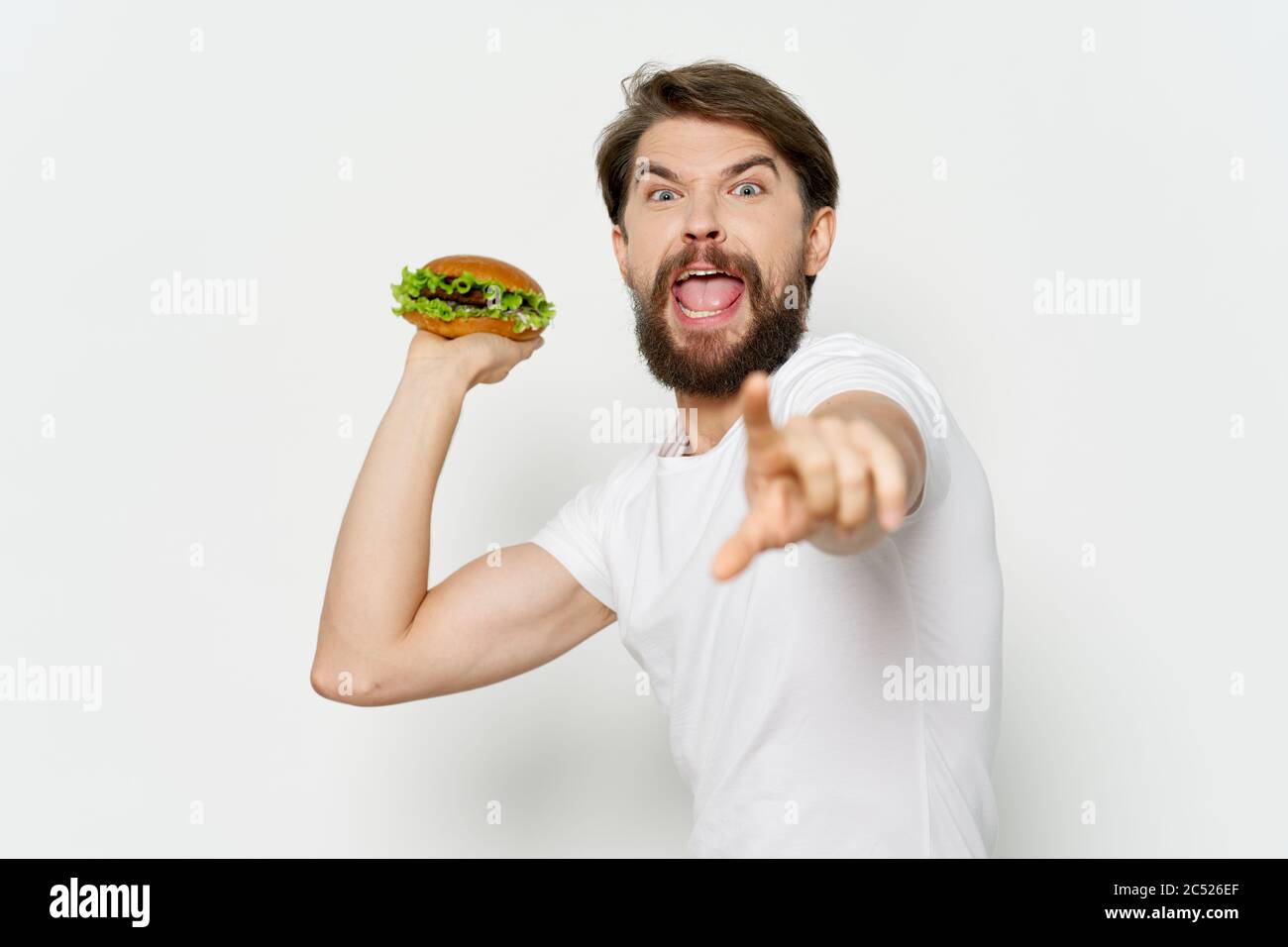 Throws a burger on an isolated background aggression wide open mouth ...