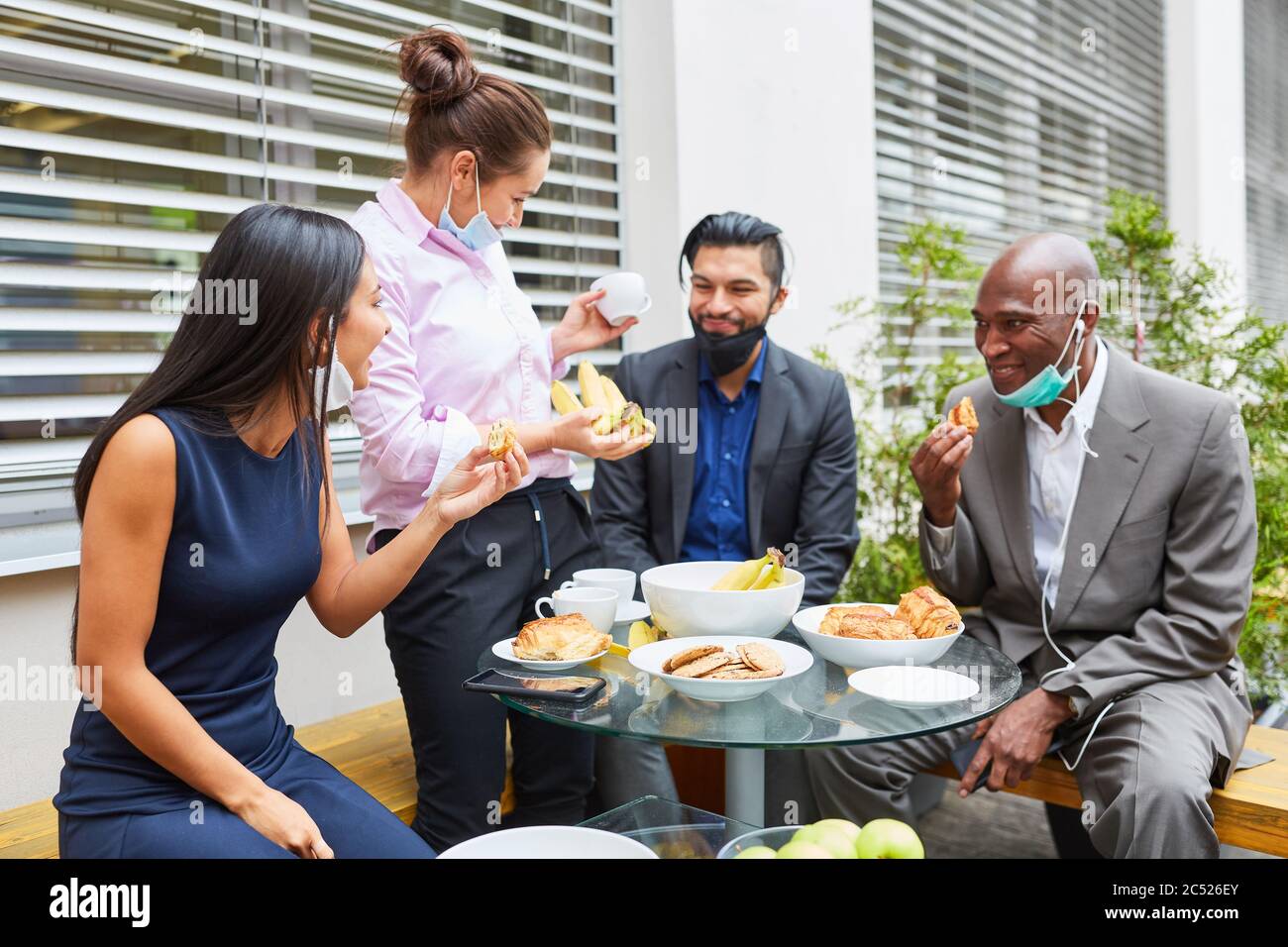 Multicultural business team eating lunch during a lunch break with ...