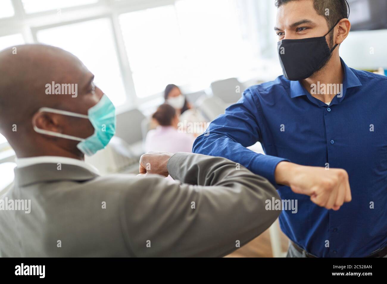 Two business people greeting at distance with their elbows as a ...