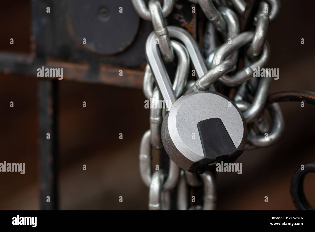 Metal lock and chains outside of closed shop for security. Dark rusted ...