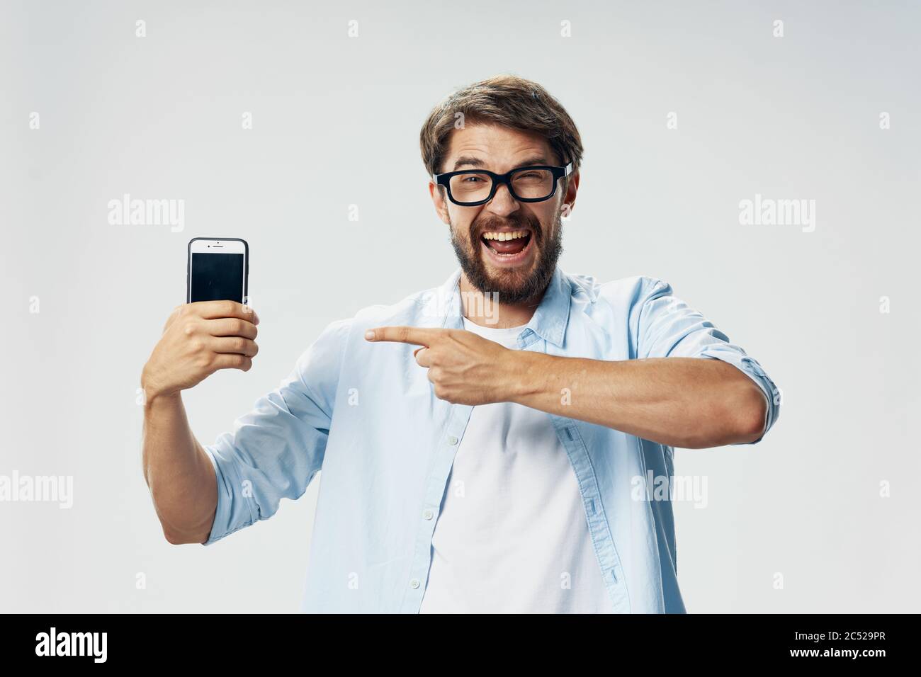 Cheerful emotional man holding a phone emotion model Stock Photo - Alamy