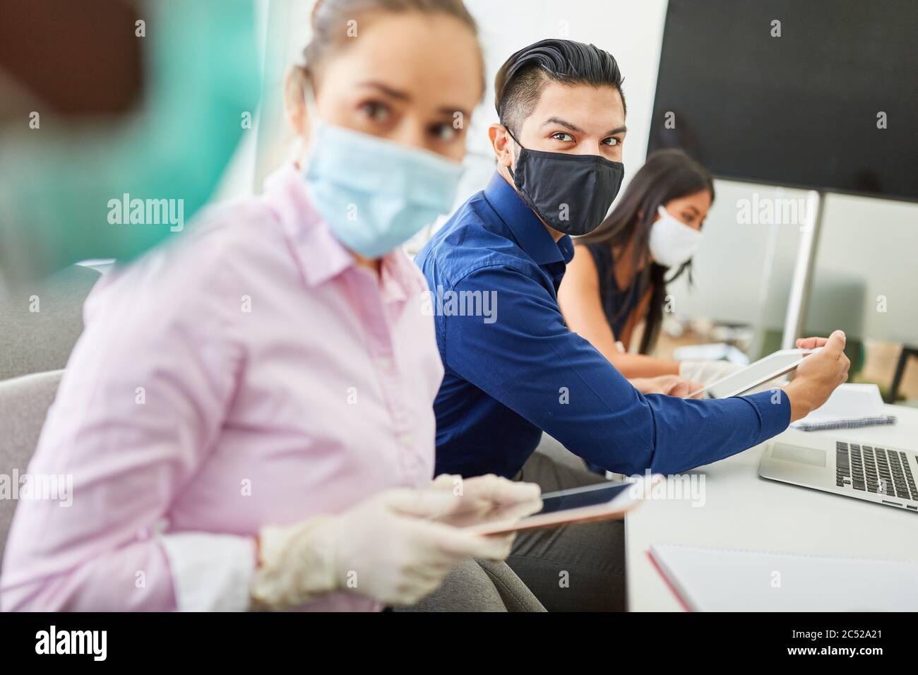 Business people with face mask in a workshop get instruction in video ...