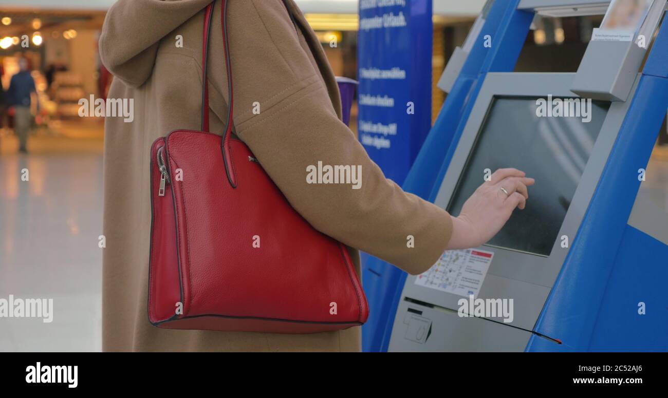 Woman doing self-check in at the airport Stock Photo - Alamy