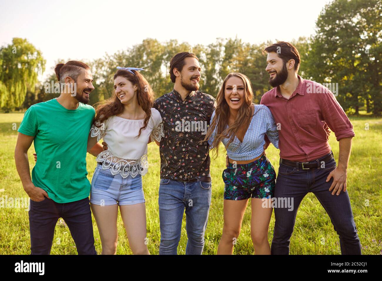Portrait of happy friends posing in countryside during summer vacation ...