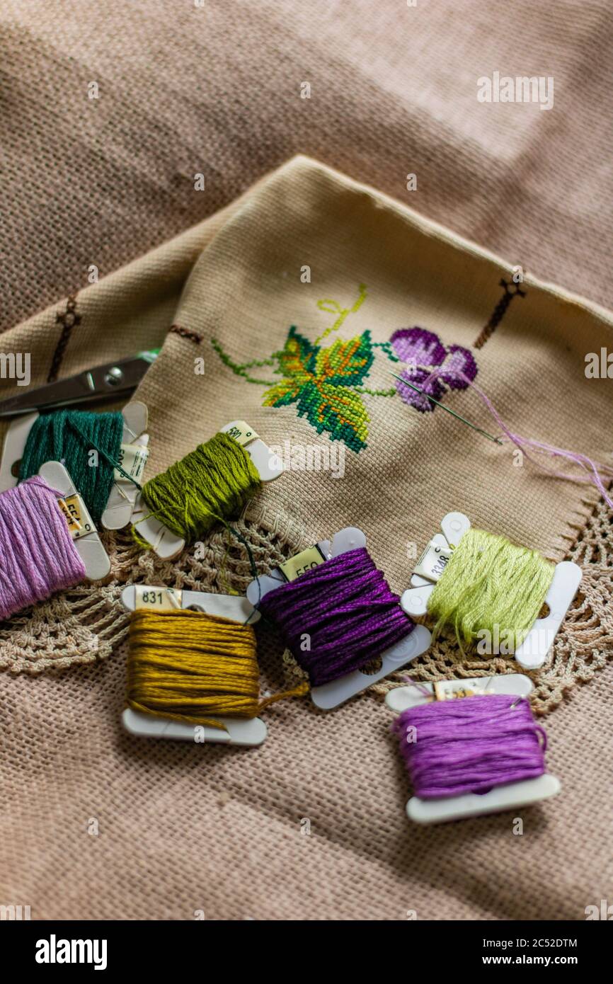 Paper spools of colorful threads and an embroidered piece of fabric ...